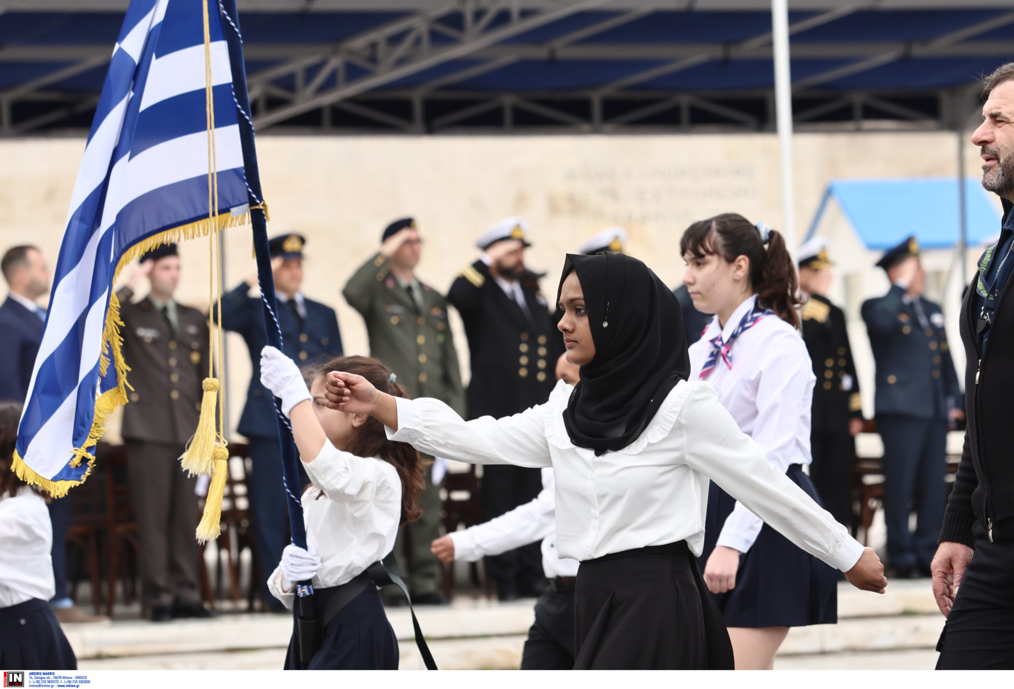 25η Μαρτίου: Εκπαιδευτικός με κόκκινες μπότες, πλακάτ με «πολύχρωμα ...